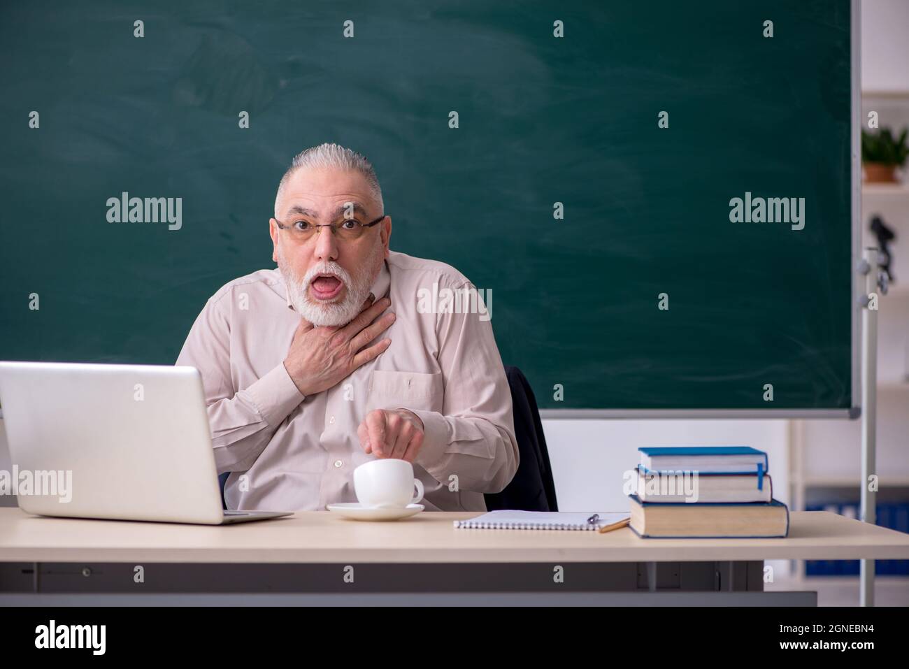 Old teacher drinking coffee in the classroom Stock Photo - Alamy