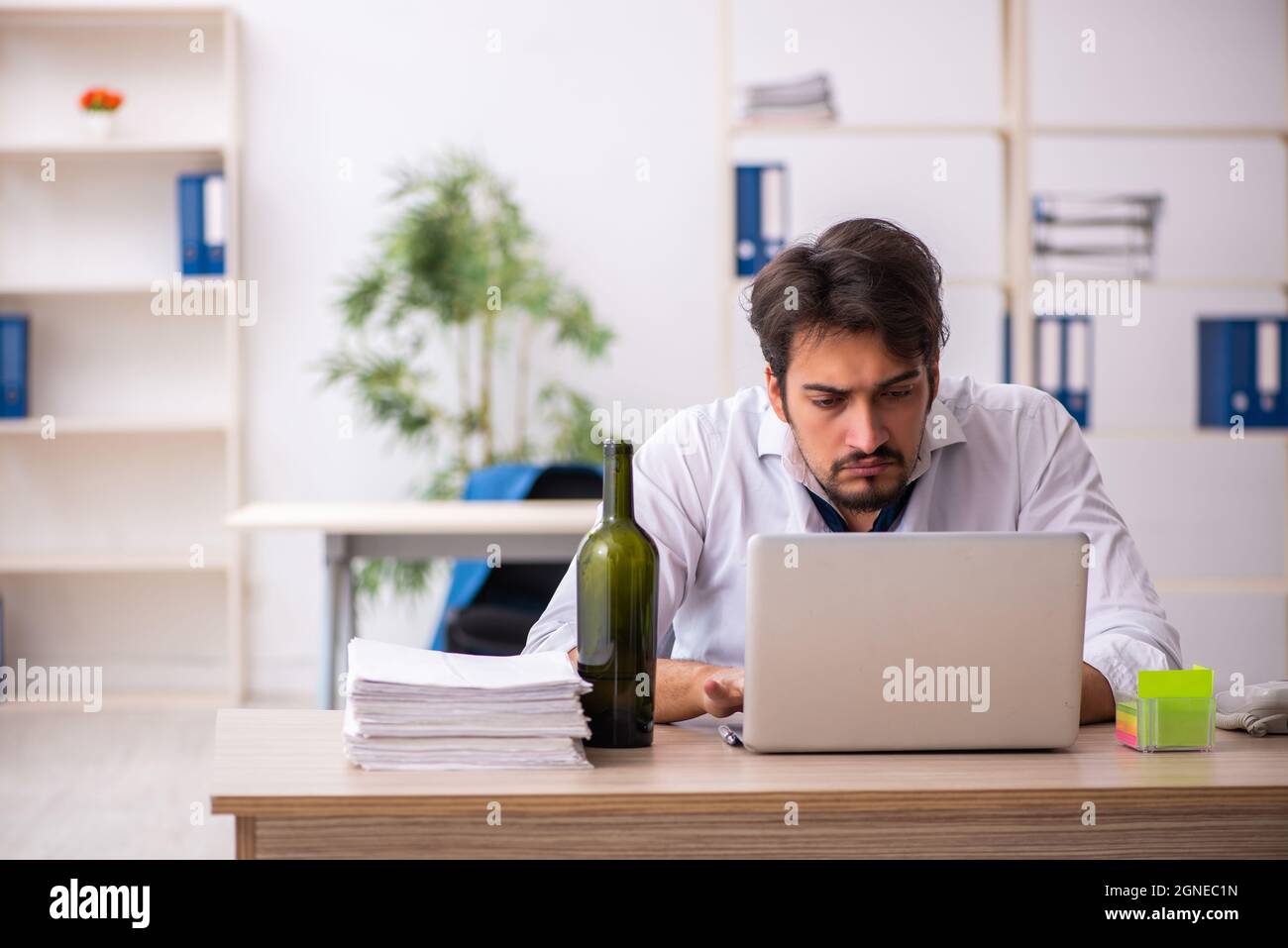 Male alcohol addicted employee sitting in the office Stock Photo - Alamy