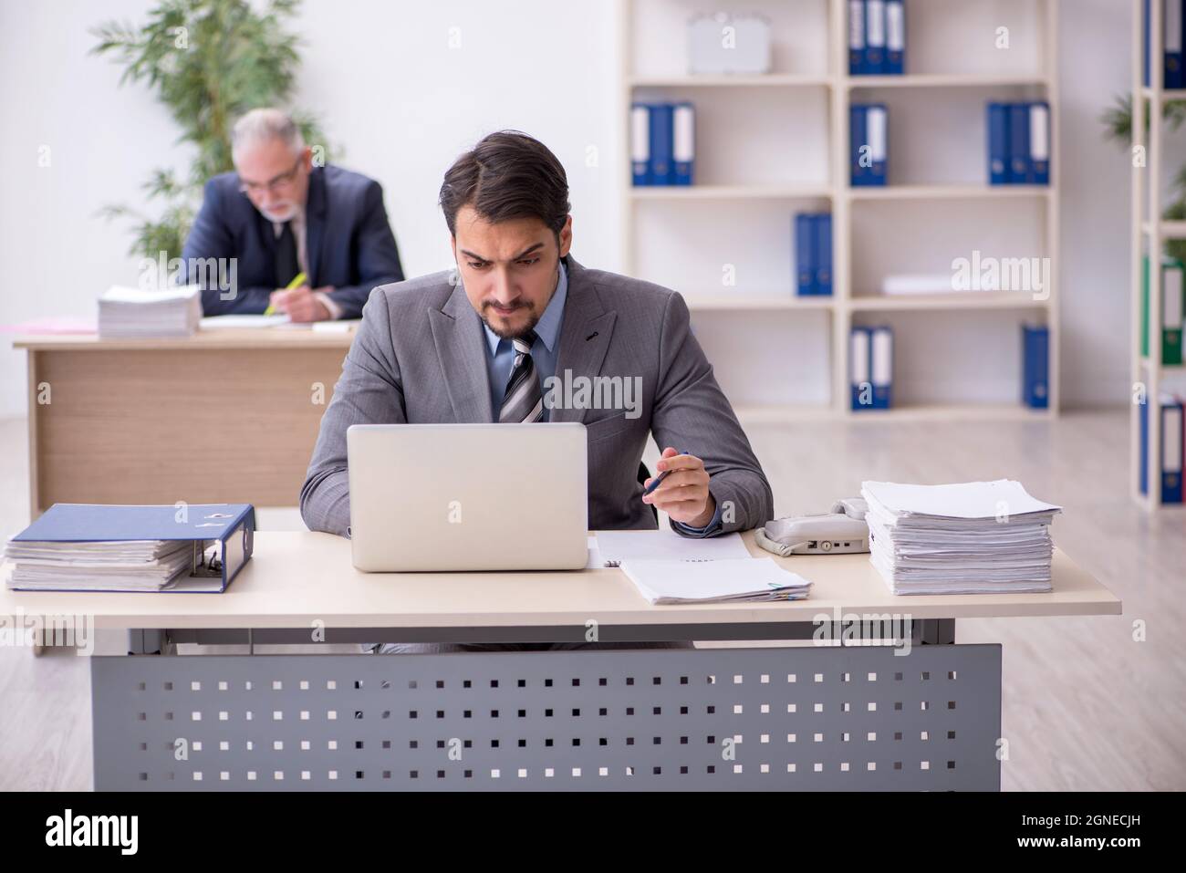 Two male employees working at workplace Stock Photo - Alamy