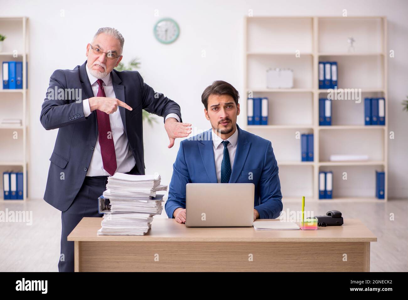 Old boss and young employee in bullying concept Stock Photo - Alamy