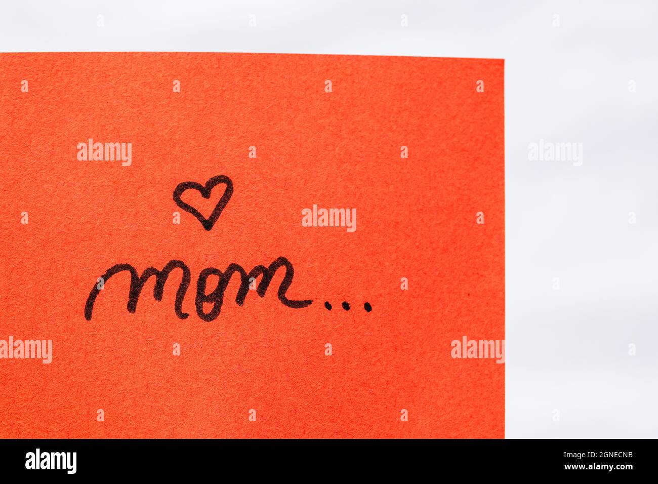 Mom handwriting text close up isolated on orange paper with copy space ...