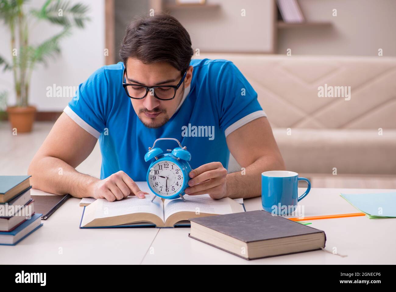 Young student studying at home in time management concept Stock Photo ...