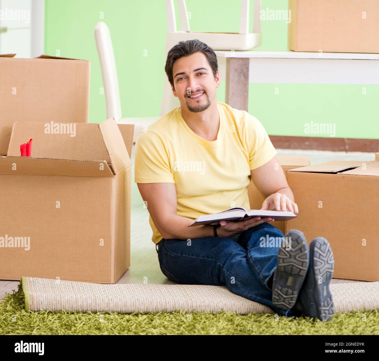The young handsome man moving in to new house with boxes Stock Photo ...