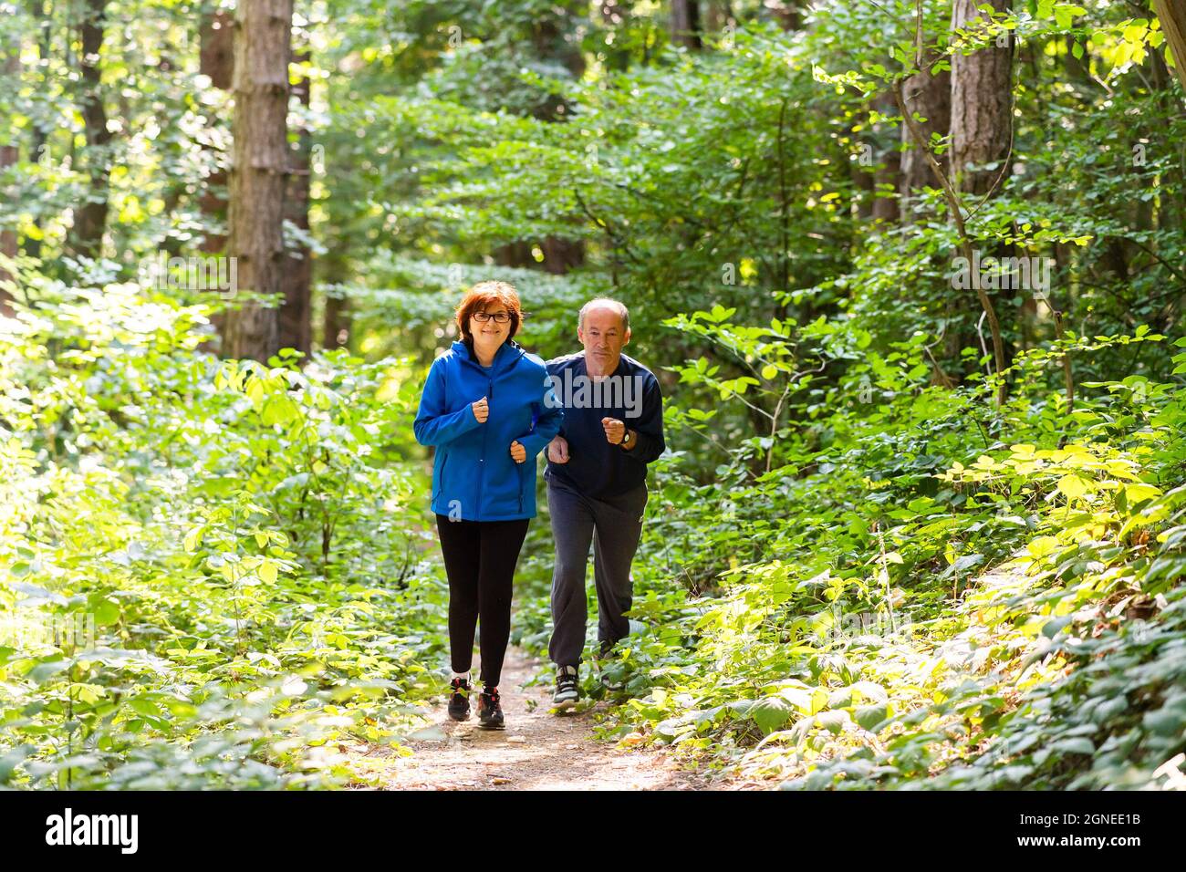 Happy senior couple running together in the park Stock Photo - Alamy