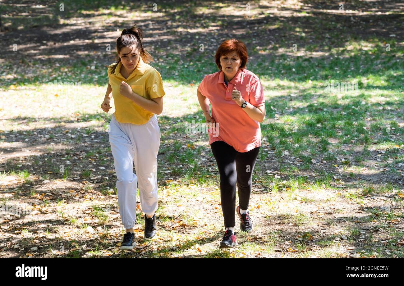 Active family - mother with daughter jumping, running in park Stock ...