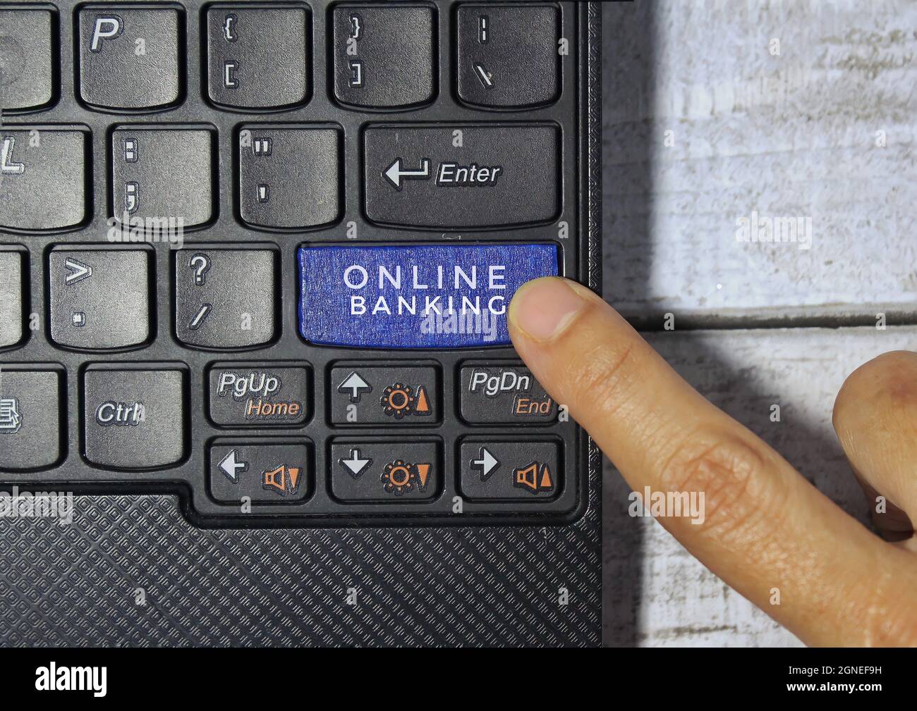 Finger pressing a blue key labeled ONLINE BANKING with symbol on a ...