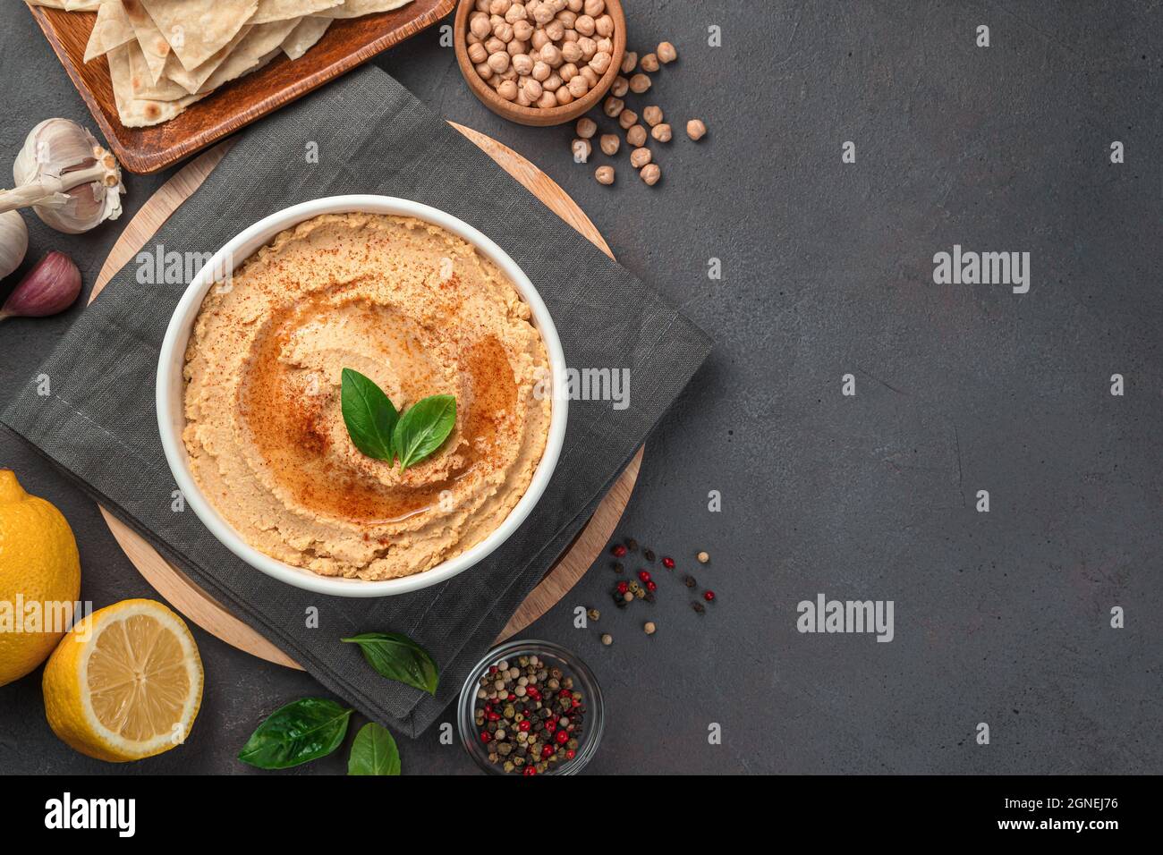 Traditional hummus with sesame, lemon and garlic on a dark background ...