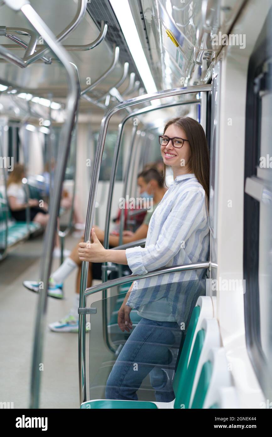 Happy young girl inside metro subway carriage student return home from ...