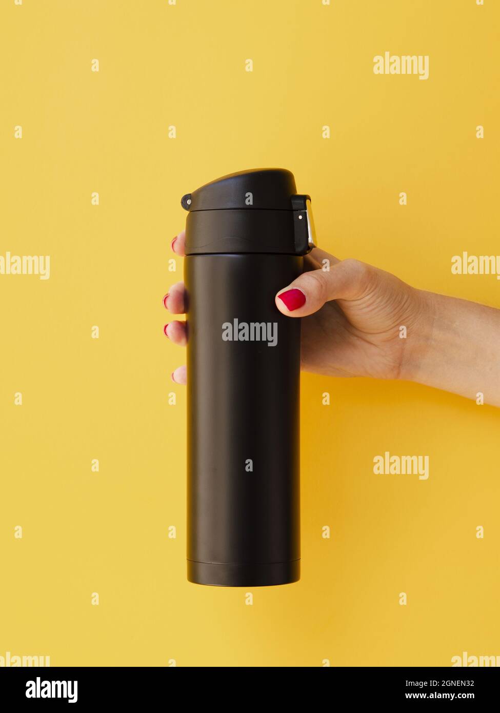 hand holding thermos mock up yellow background. High quality and ...