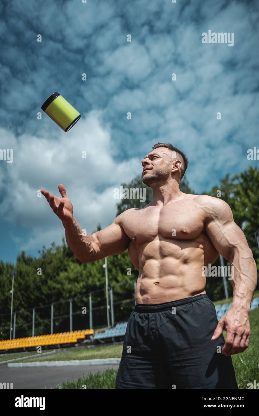 muscular bodybuilder male throw up container with protein whey powder ...