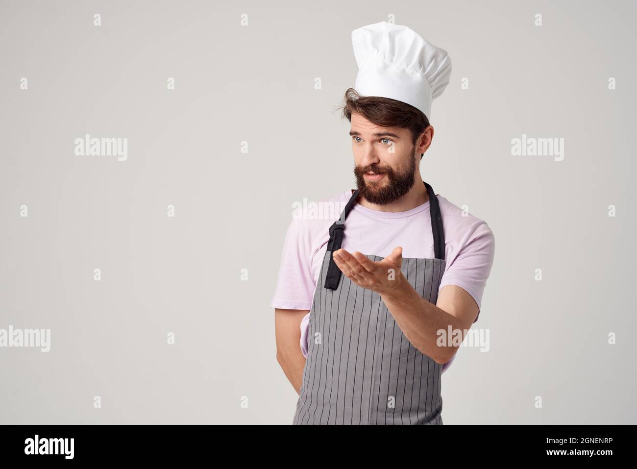 a man in an apron with a cap on his head chef professional work Stock ...
