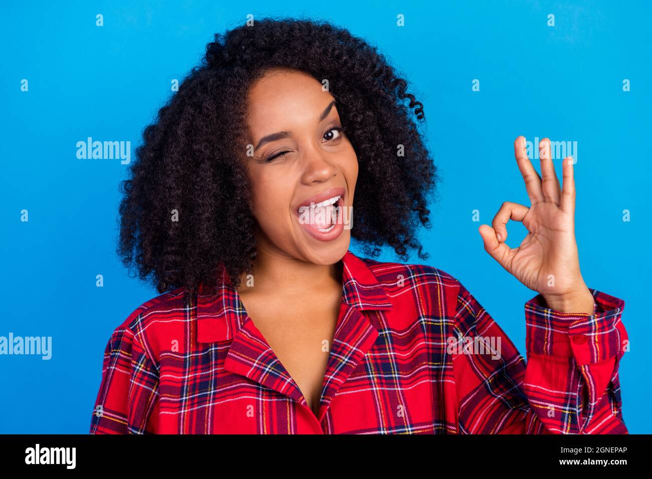 Photo of funny young brunette lady show okey blink wear red checkered ...