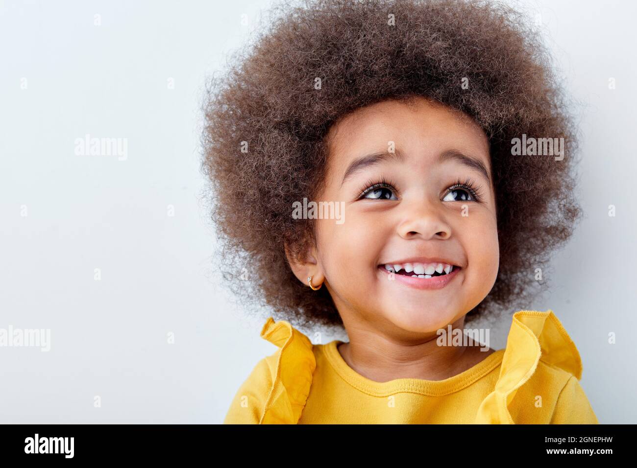 Surprised little afro black girl isolated on white studio background ...