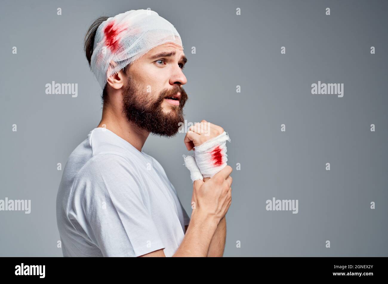 Man bandaged head and hand blood light background Stock Photo - Alamy