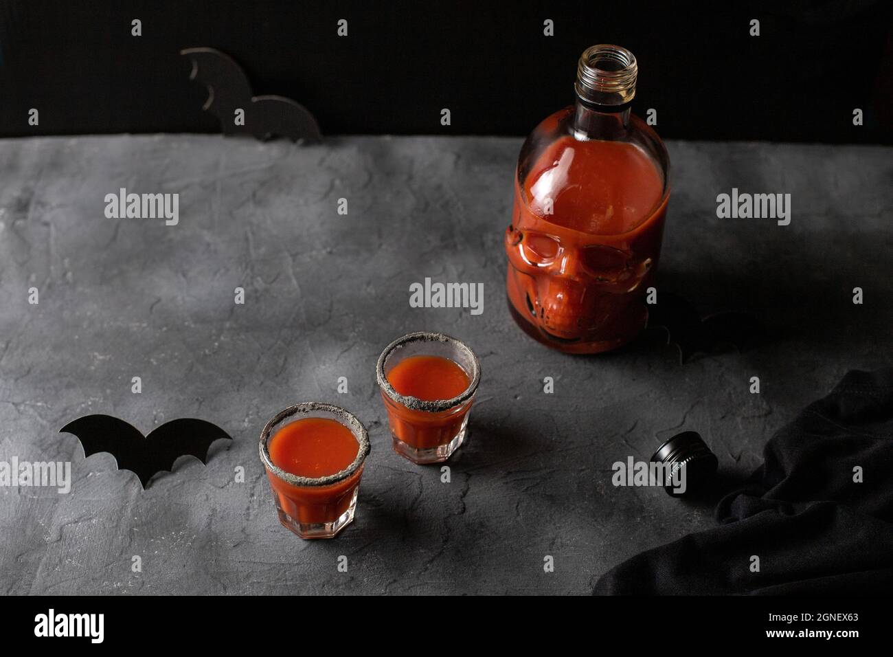 Tomato cocktail in a skull-shaped bottle and glasses. Drink for ...