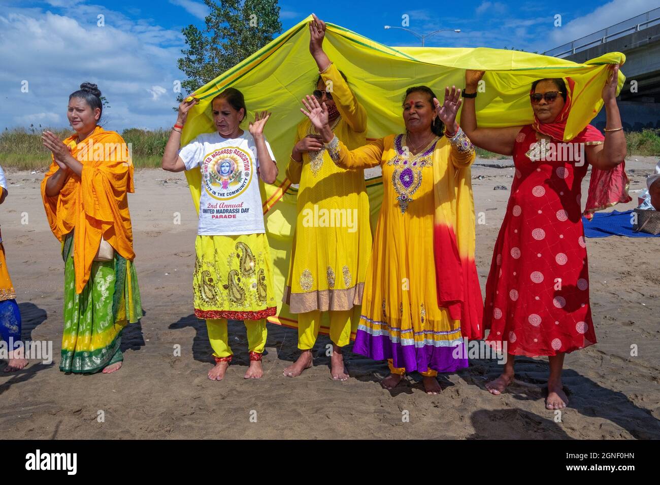 Devout Hindu women pray and look for shade at a seaside Ganga and ...