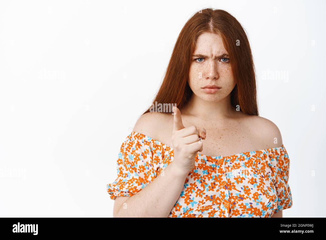 Angry redhead girl shaking finger, scolding someone, threatening ...