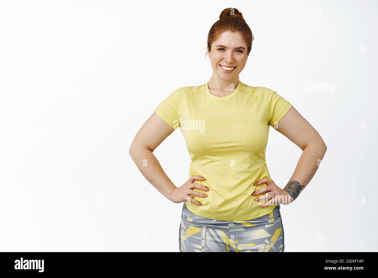 Smiling curvy girl workout in fitness clothing, holding hands on waist ...