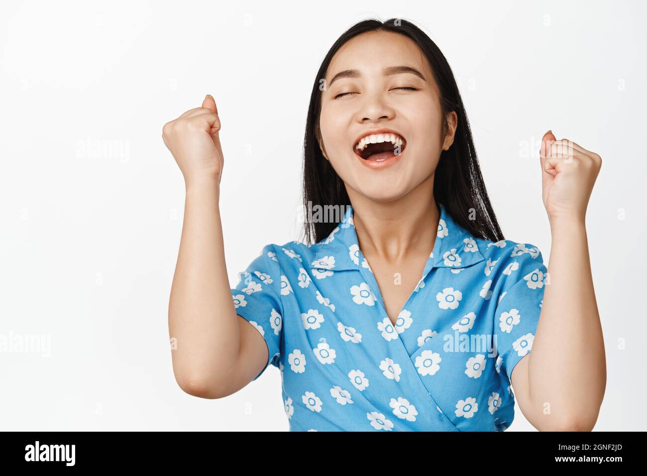 Relieved happy asian girl fist pump, laughing and smiling with ...