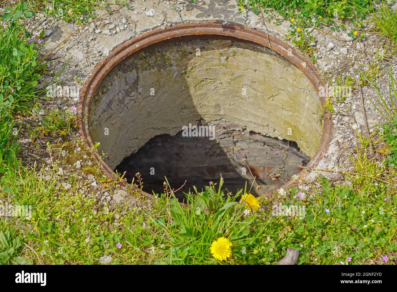 Open shaft deep hole in park hidden danger Stock Photo - Alamy