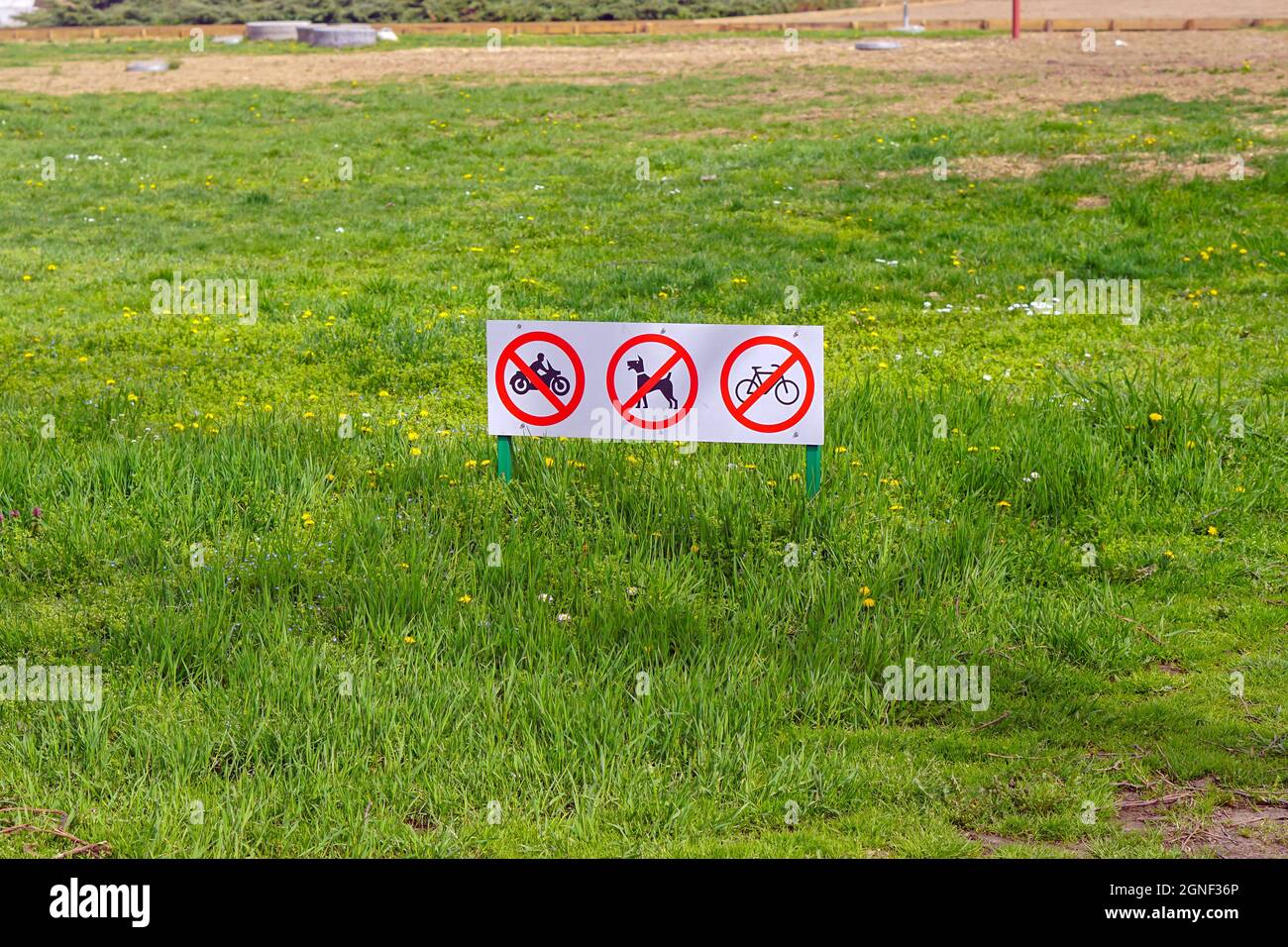 Restrictions warning signs board at green grass in park Stock Photo - Alamy