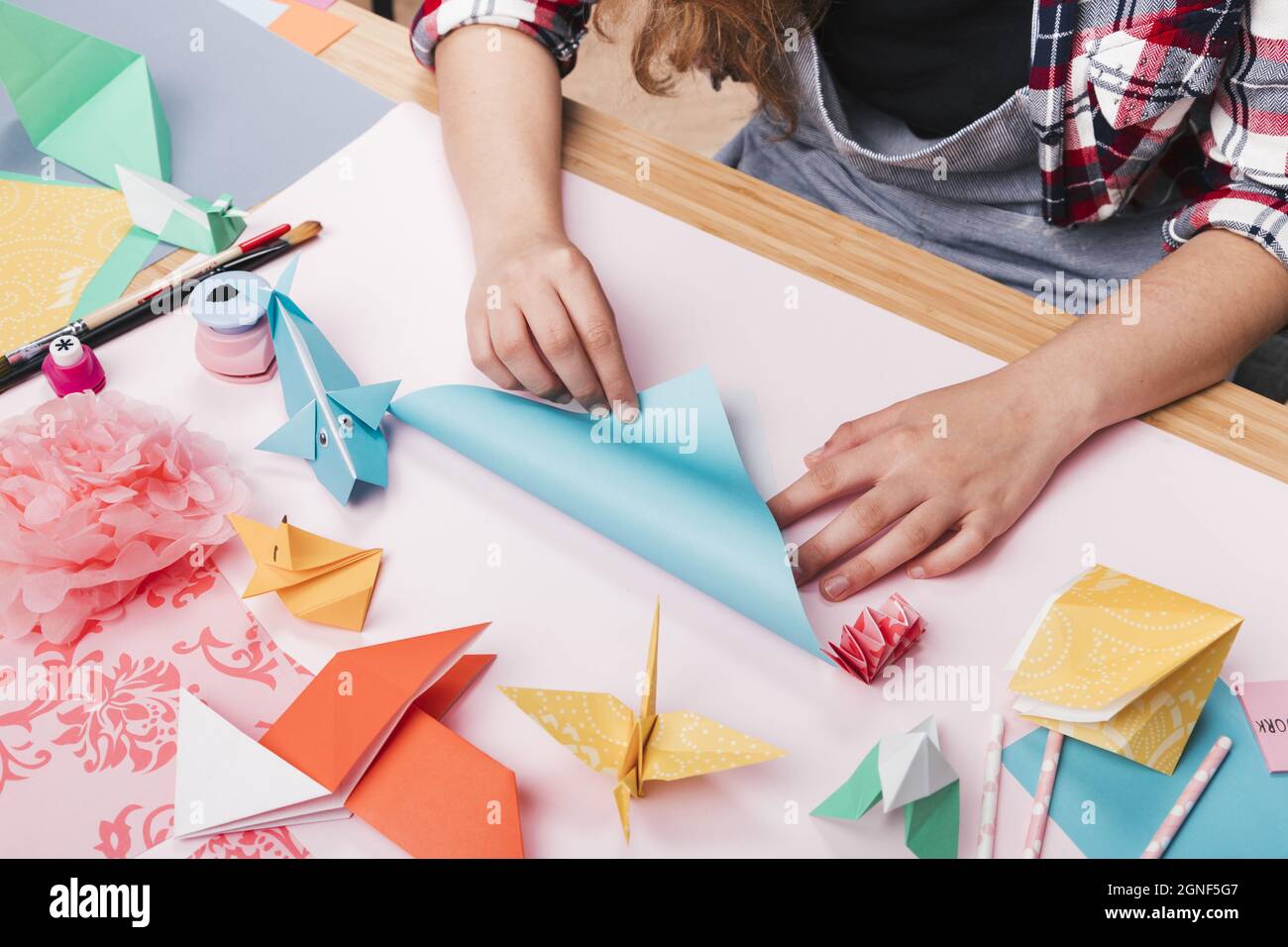female artist folding origami paper making beautiful craft. High ...