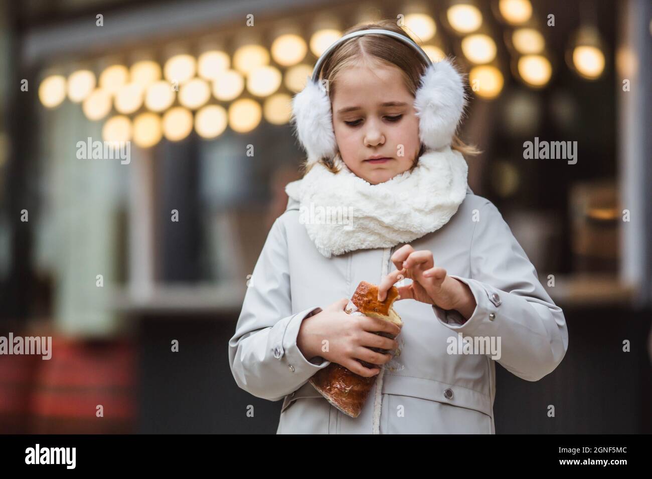 A cute little girl eats a traditional Hungarian sweet pastry called ...