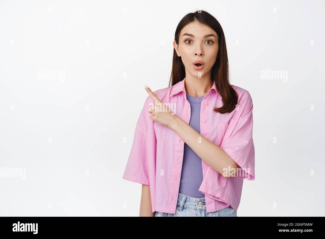 Wow look at that. Surprised girl pointing finger left and looking ...