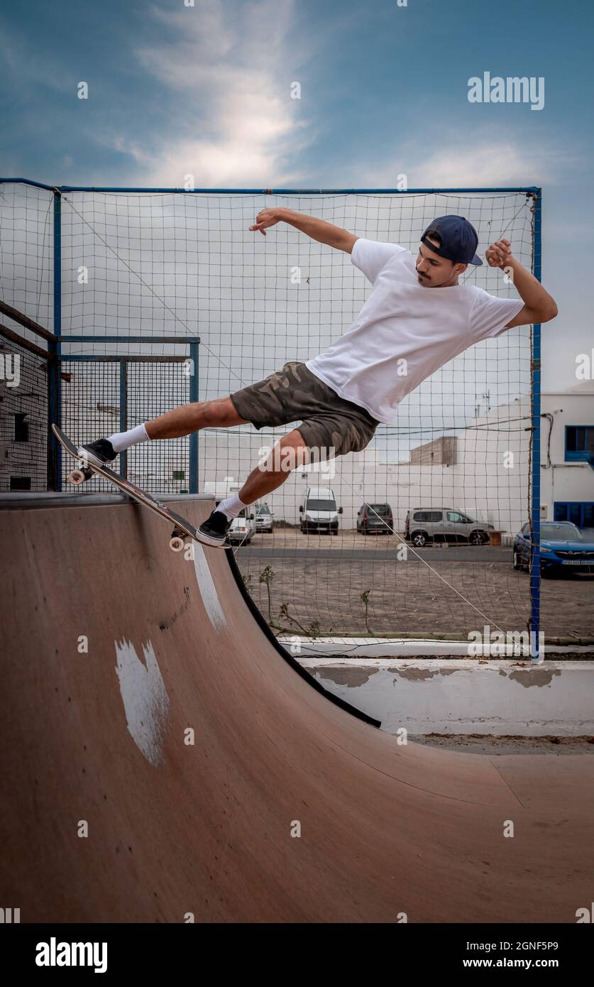 young man skateboarding on the ramp of a skate park. vertical ...