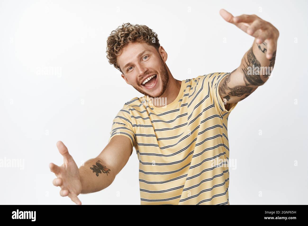 Happy blond man stretch out hands to hold something big, hugging ...