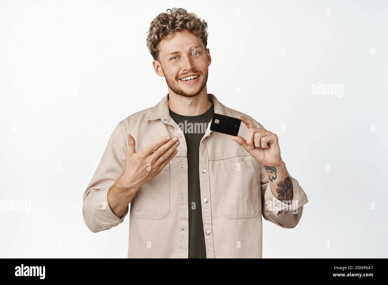 Handsome modern guy shows credit card, demonstrating new bank features ...
