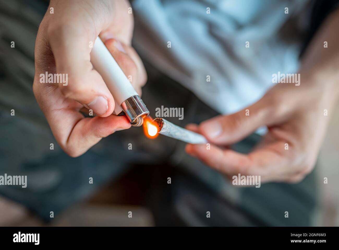 young man heats the hashish to prepare a marijuana cigarette Stock ...