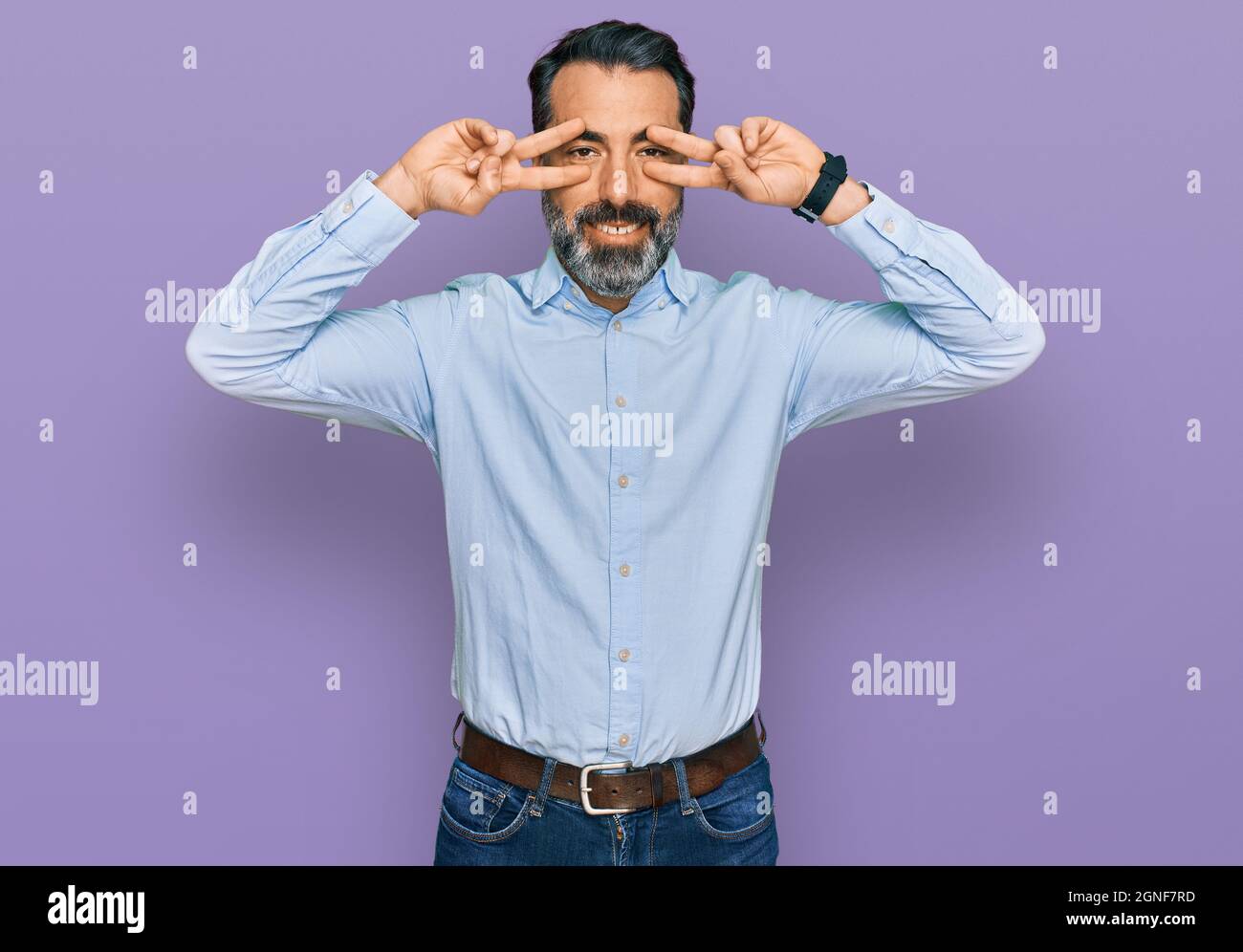 Middle aged man with beard wearing business shirt doing peace symbol ...