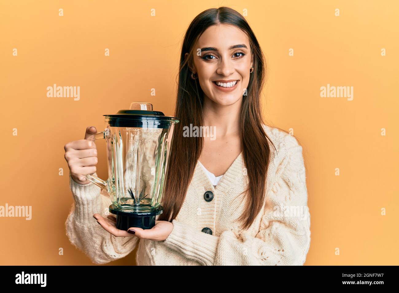 Beautiful brunette young woman holding food processor mixer machine ...