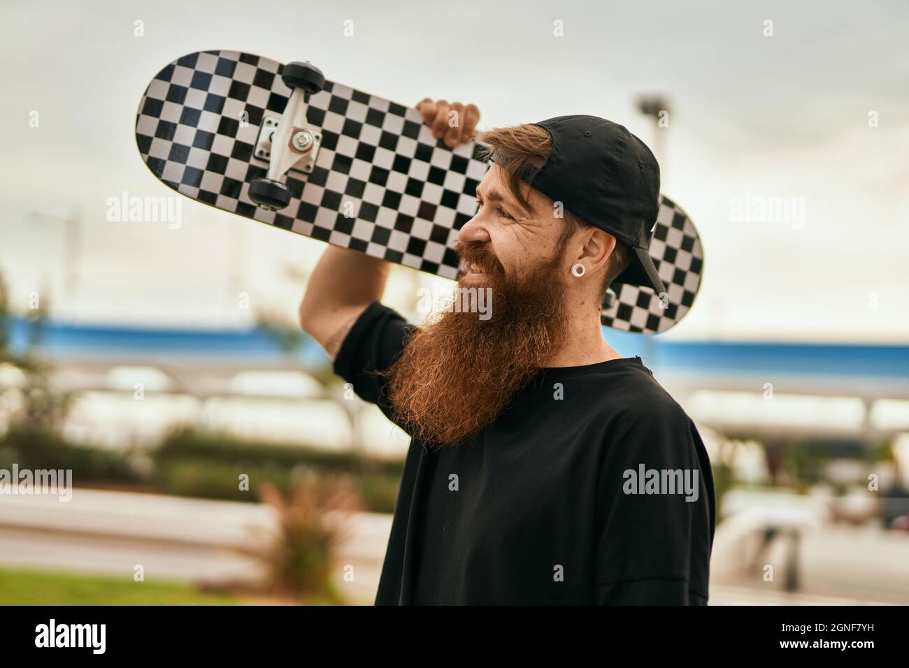 Young irish skater man smiling happy holding skate at the city Stock ...