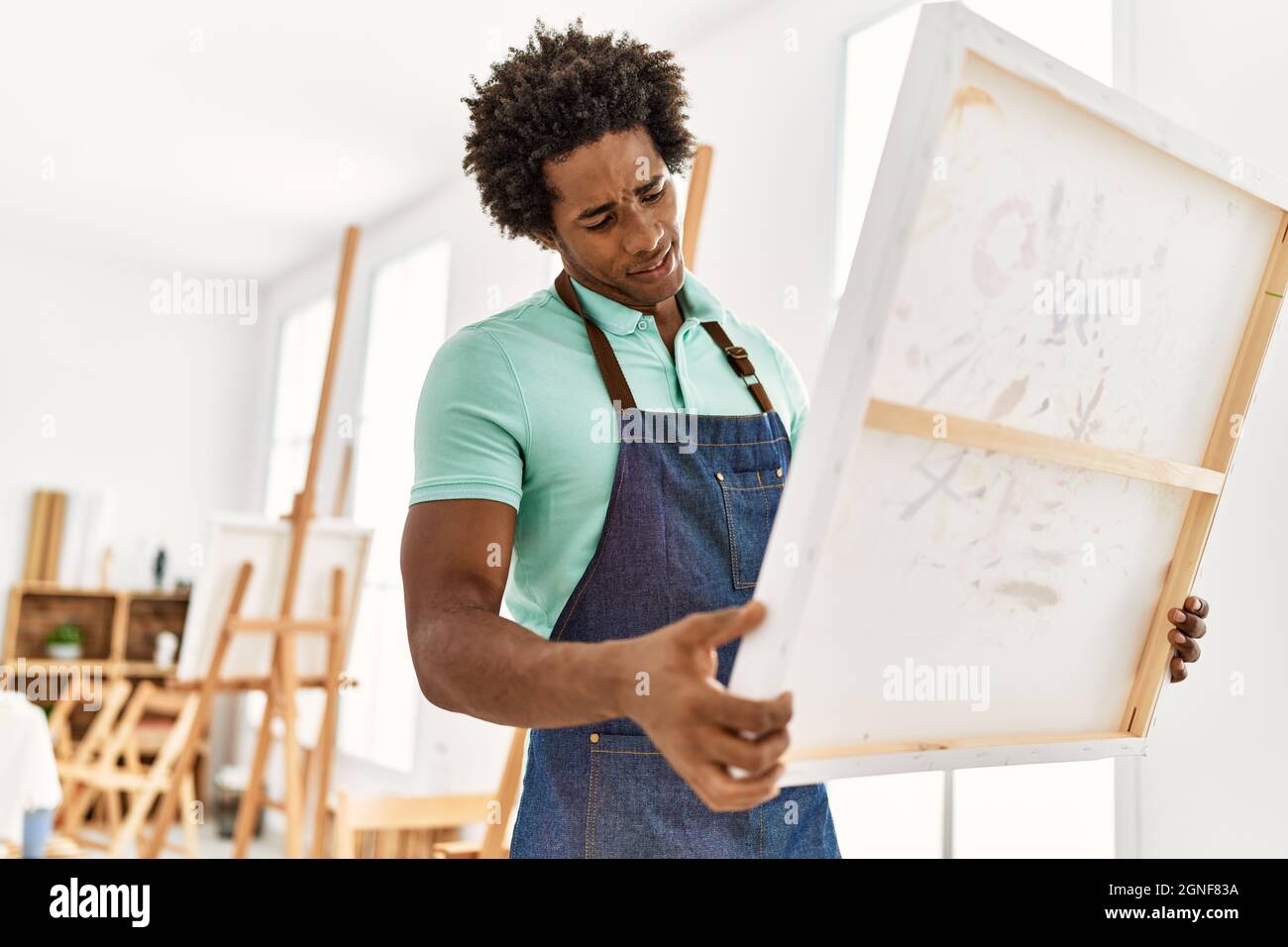 Young african american artist man with serious expression holding ...