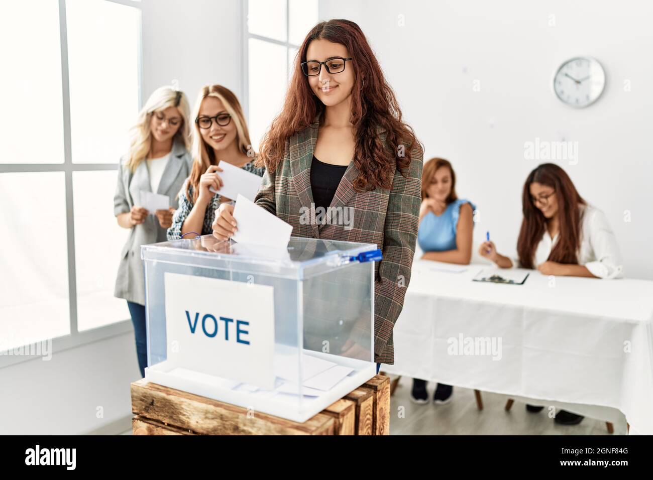 Group of young voter woman smiling happy putting vote in voting box at ...