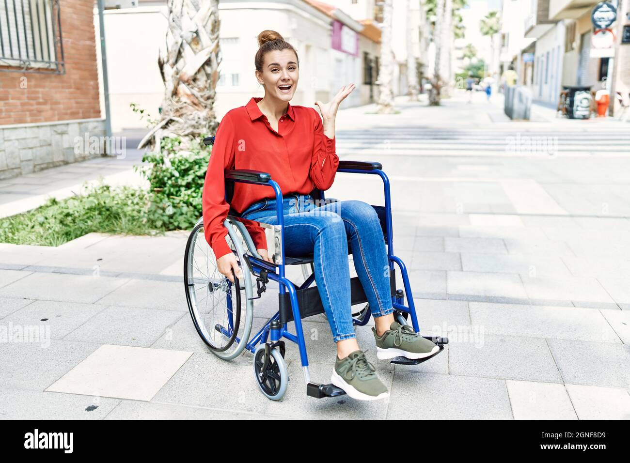 Young Brunette Woman Sitting On Wheelchair Outdoors Celebrating Victory