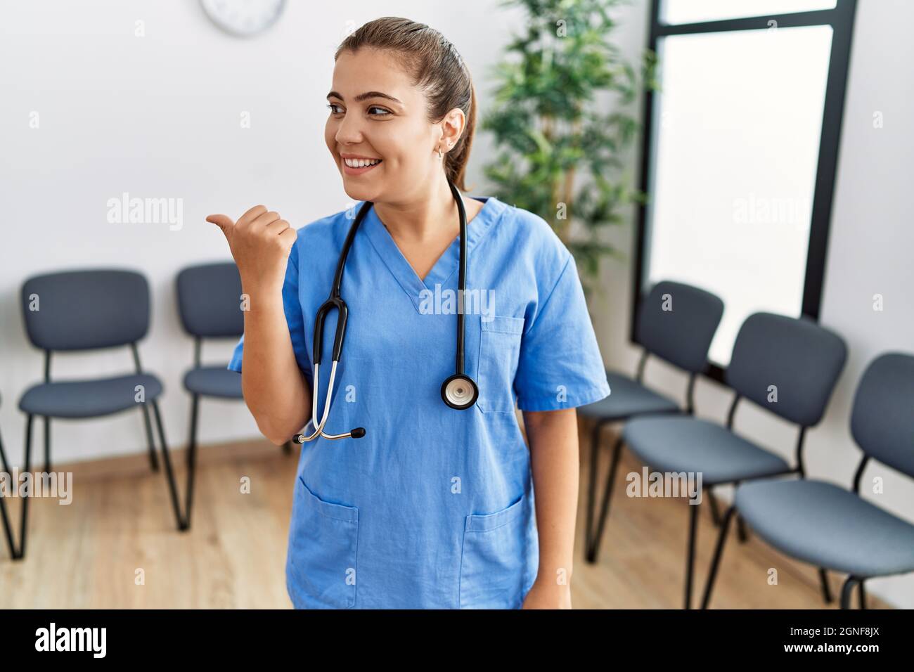 Young brunette doctor woman at waiting room smiling with happy face ...