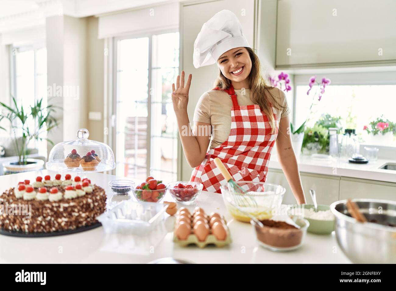 Beautiful young brunette pastry chef woman cooking pastries at the ...