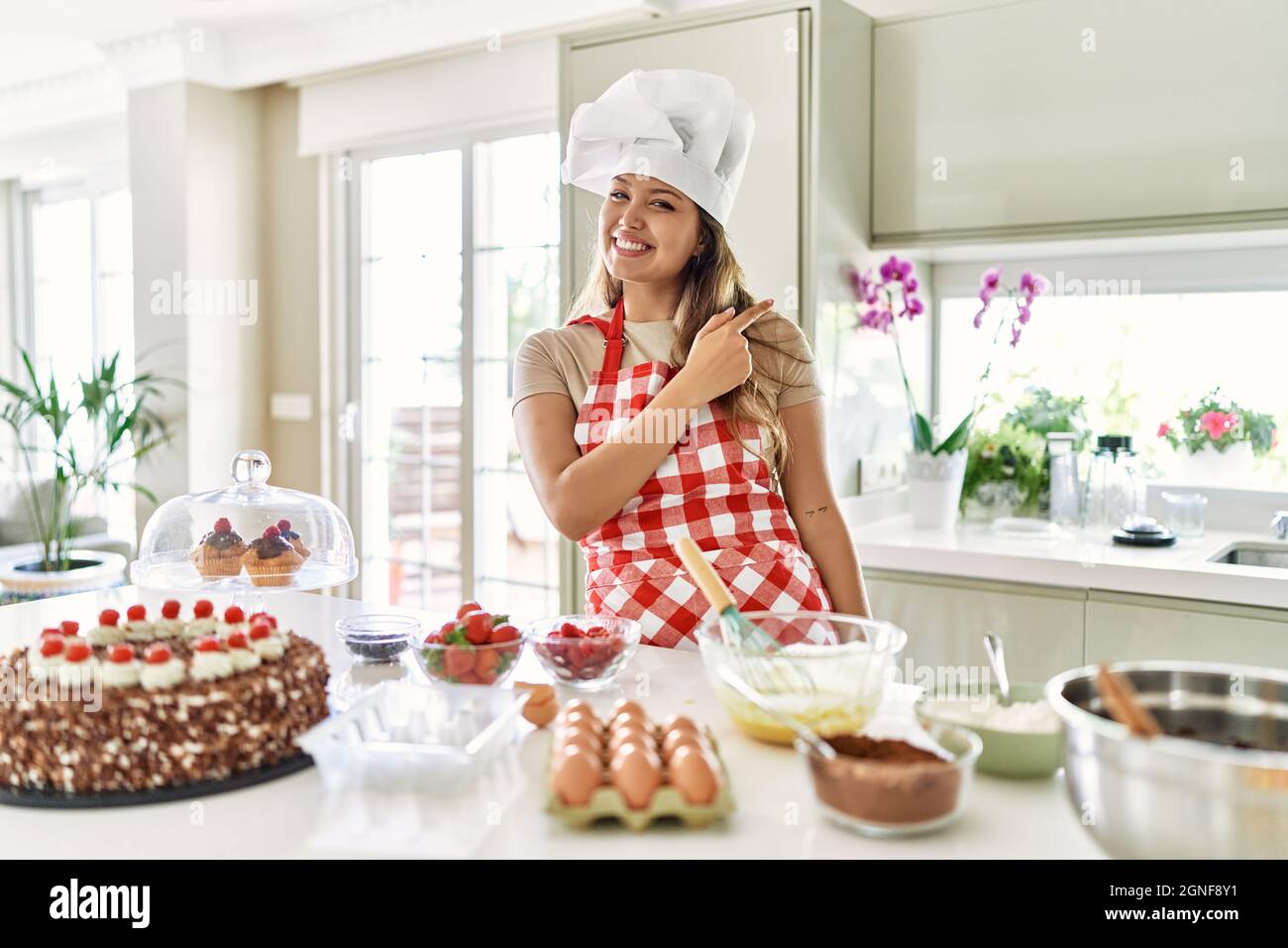 Beautiful young brunette pastry chef woman cooking pastries at the ...
