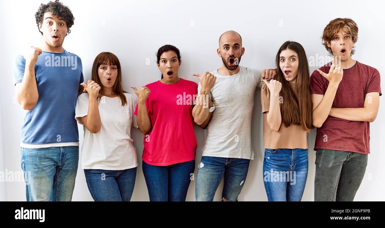Group of young friends standing together over isolated background ...