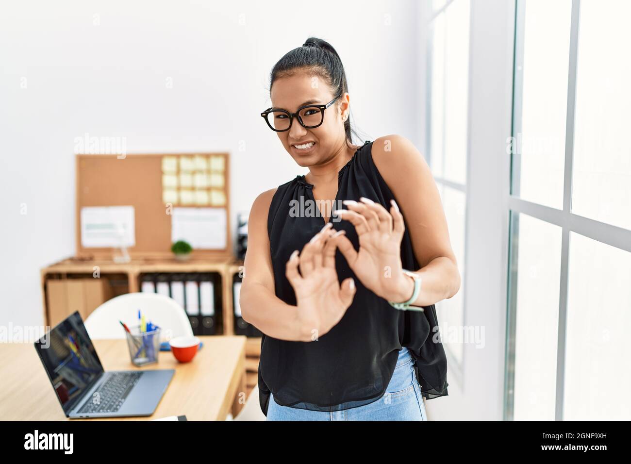 Young hispanic business woman working at the office disgusted ...