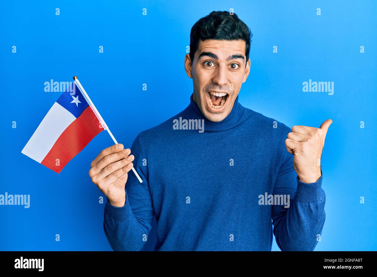 Handsome hispanic business man holding chile flag pointing thumb up to ...