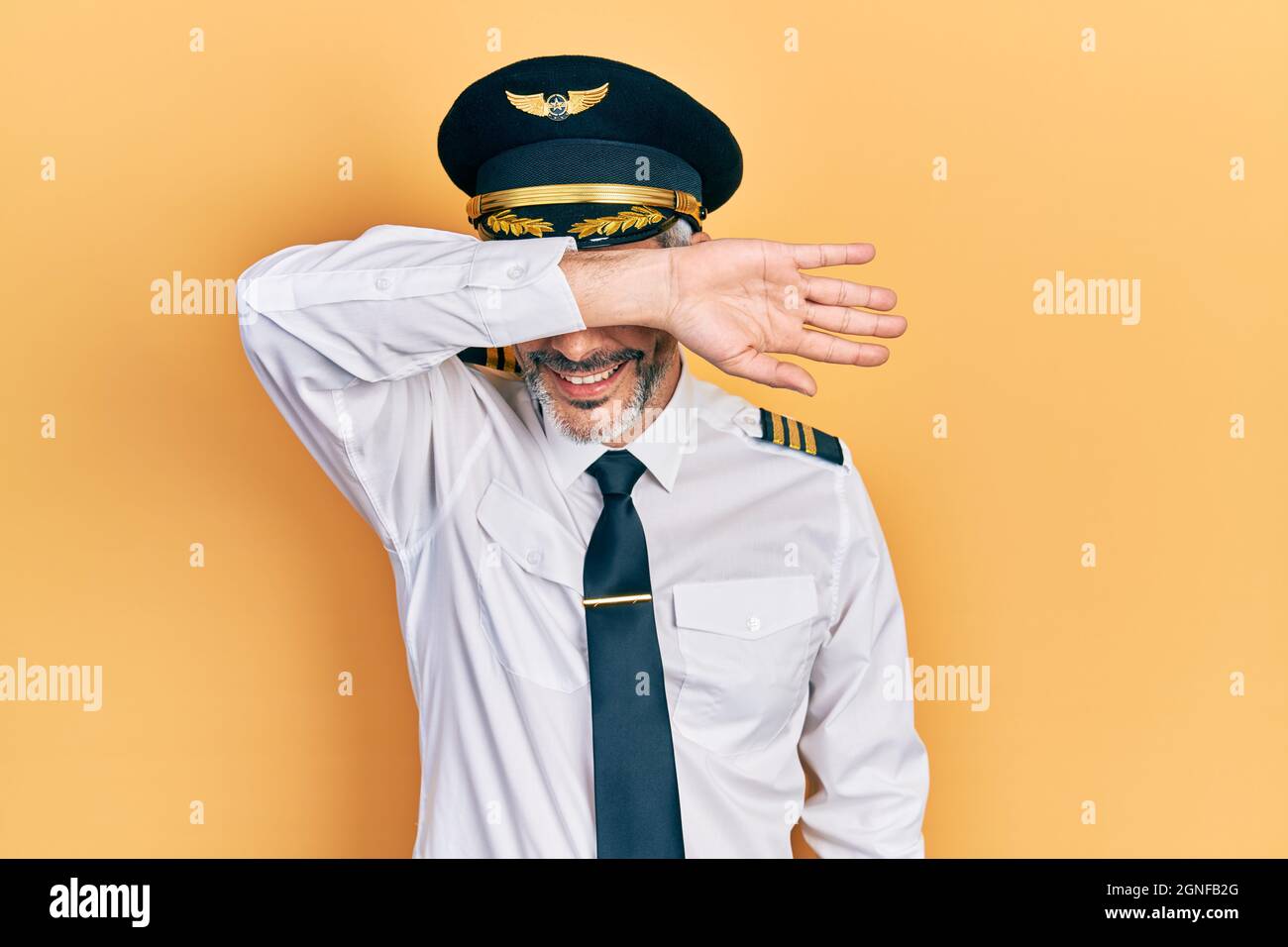 Handsome middle age man with grey hair wearing airplane pilot uniform ...