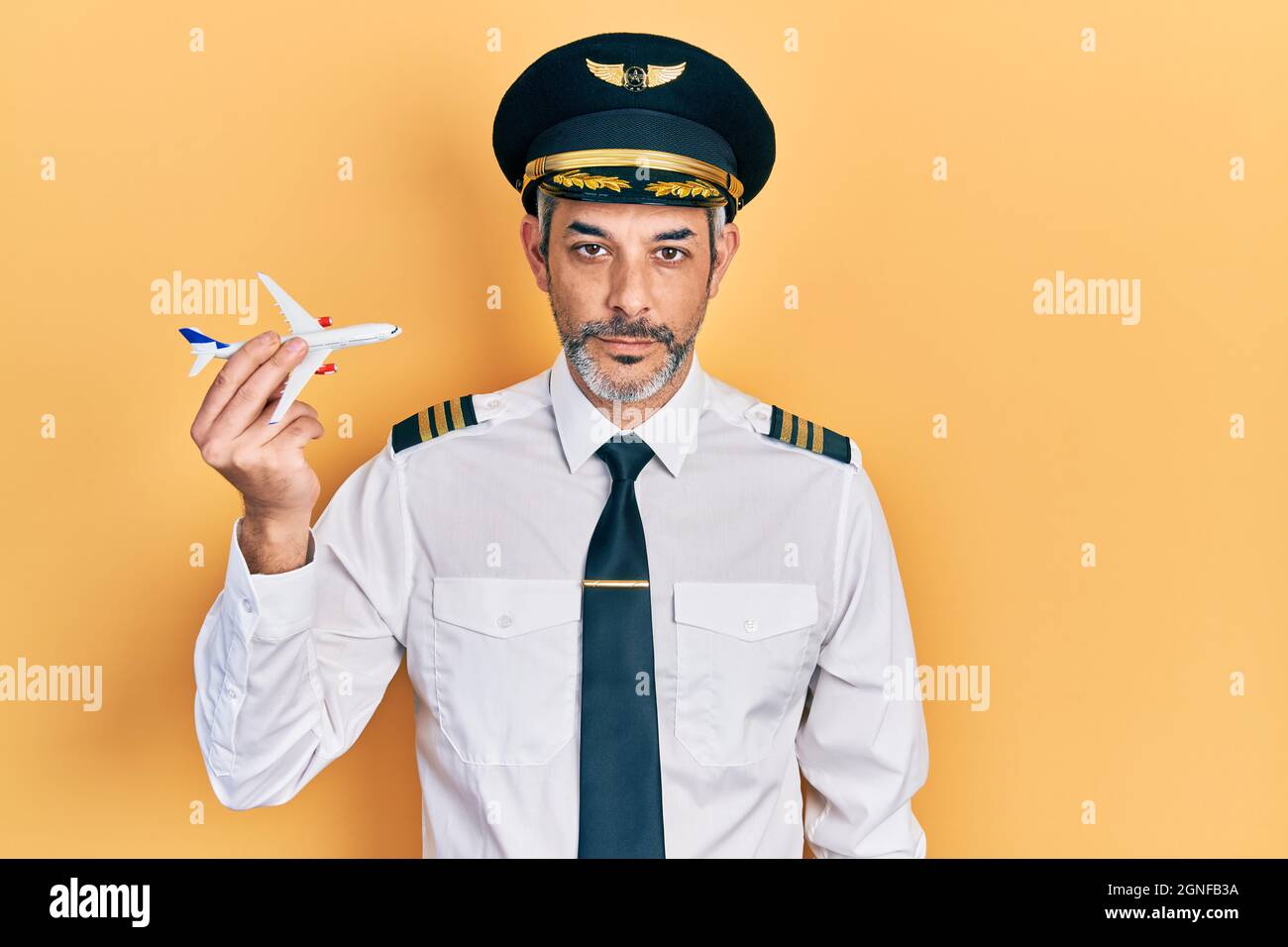 Handsome middle age man with grey hair wearing airplane pilot uniform ...
