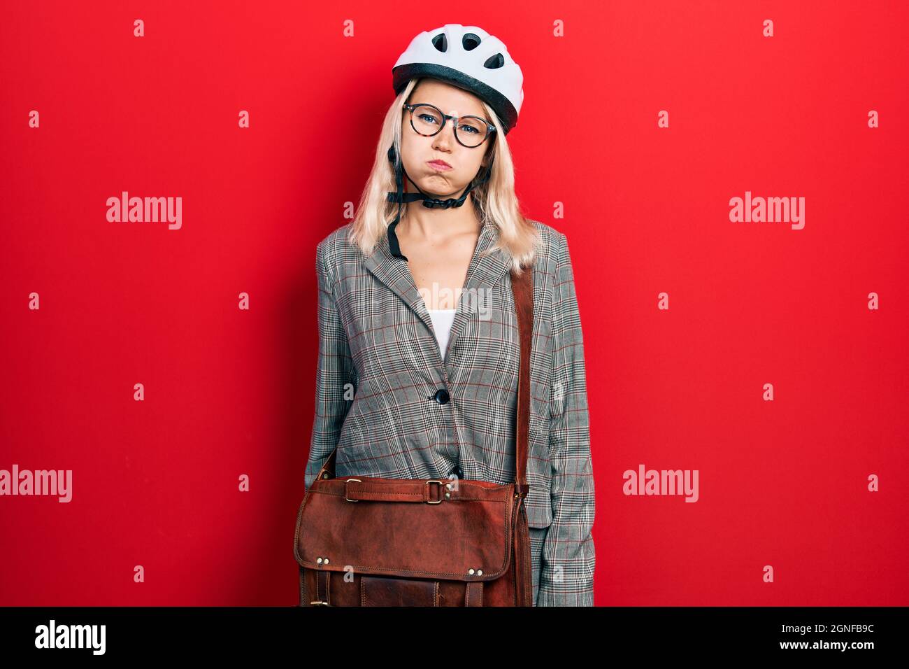 Beautiful caucasian blonde business woman wearing bike helmet puffing ...