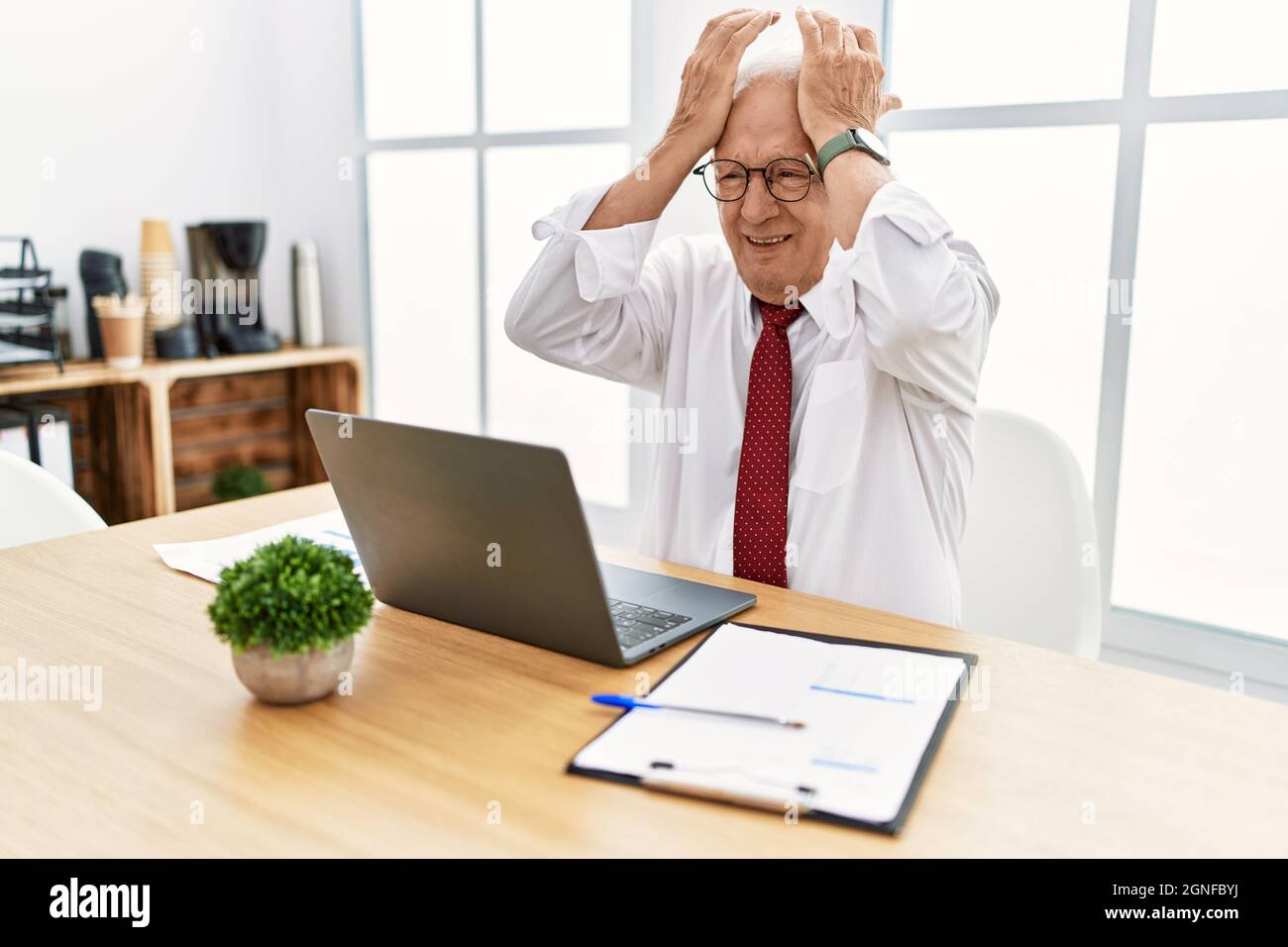 Senior man working at the office using computer laptop suffering from ...