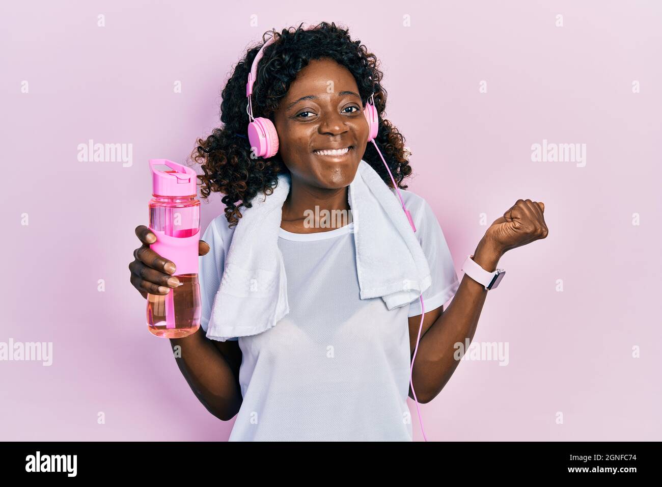 Young african american woman wearing sportswear holding water bottle ...