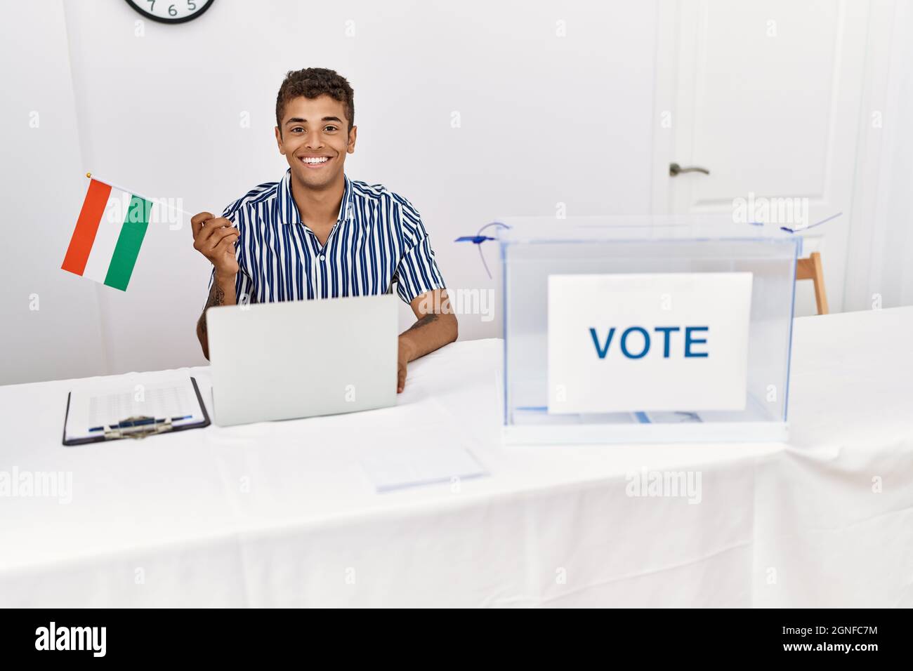 Young handsome hispanic man at political campaign election holding ...